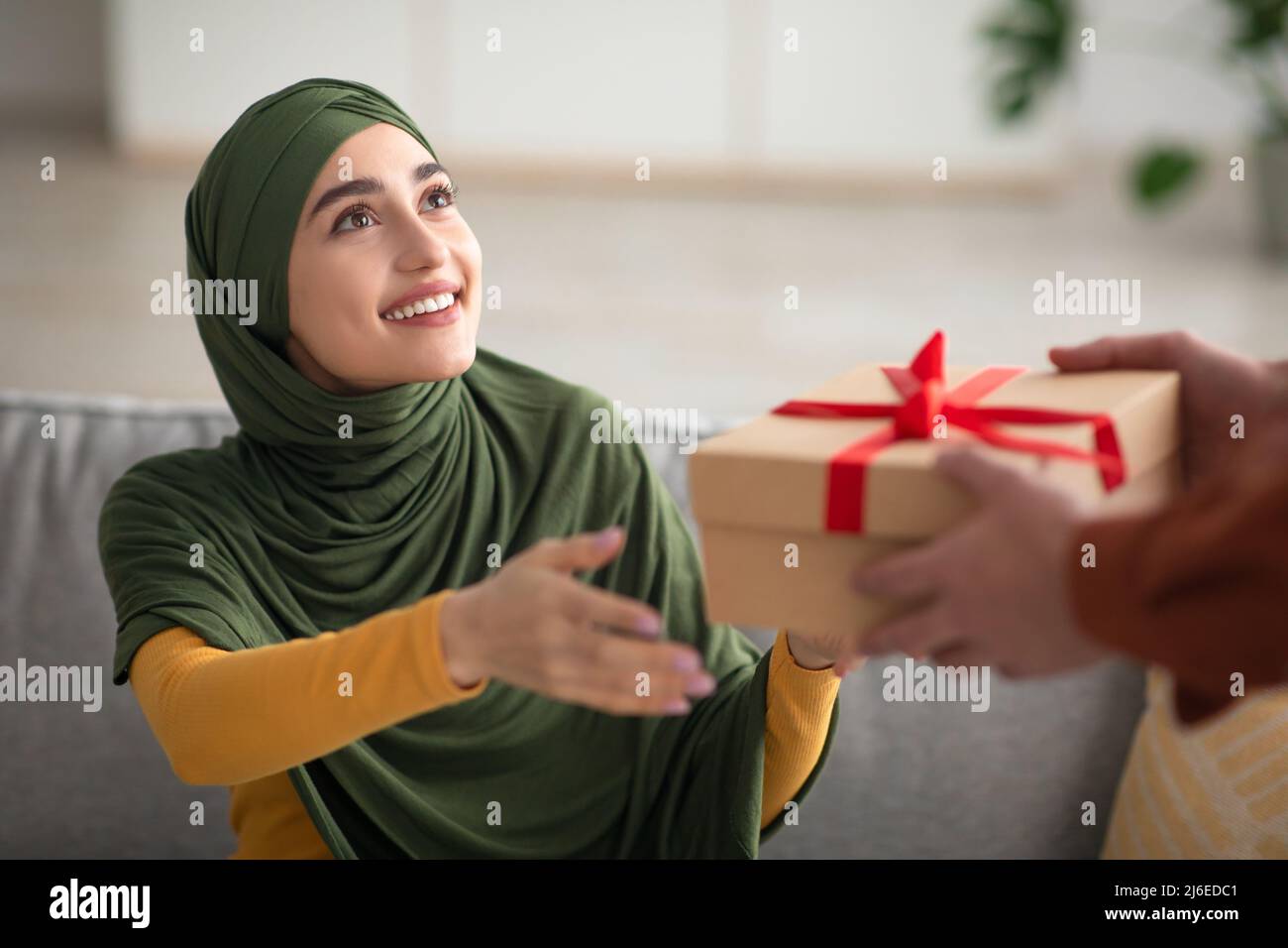 Joyful Muslim Woman Wearing Hijab Receiving Gift Box At Home Stock ...