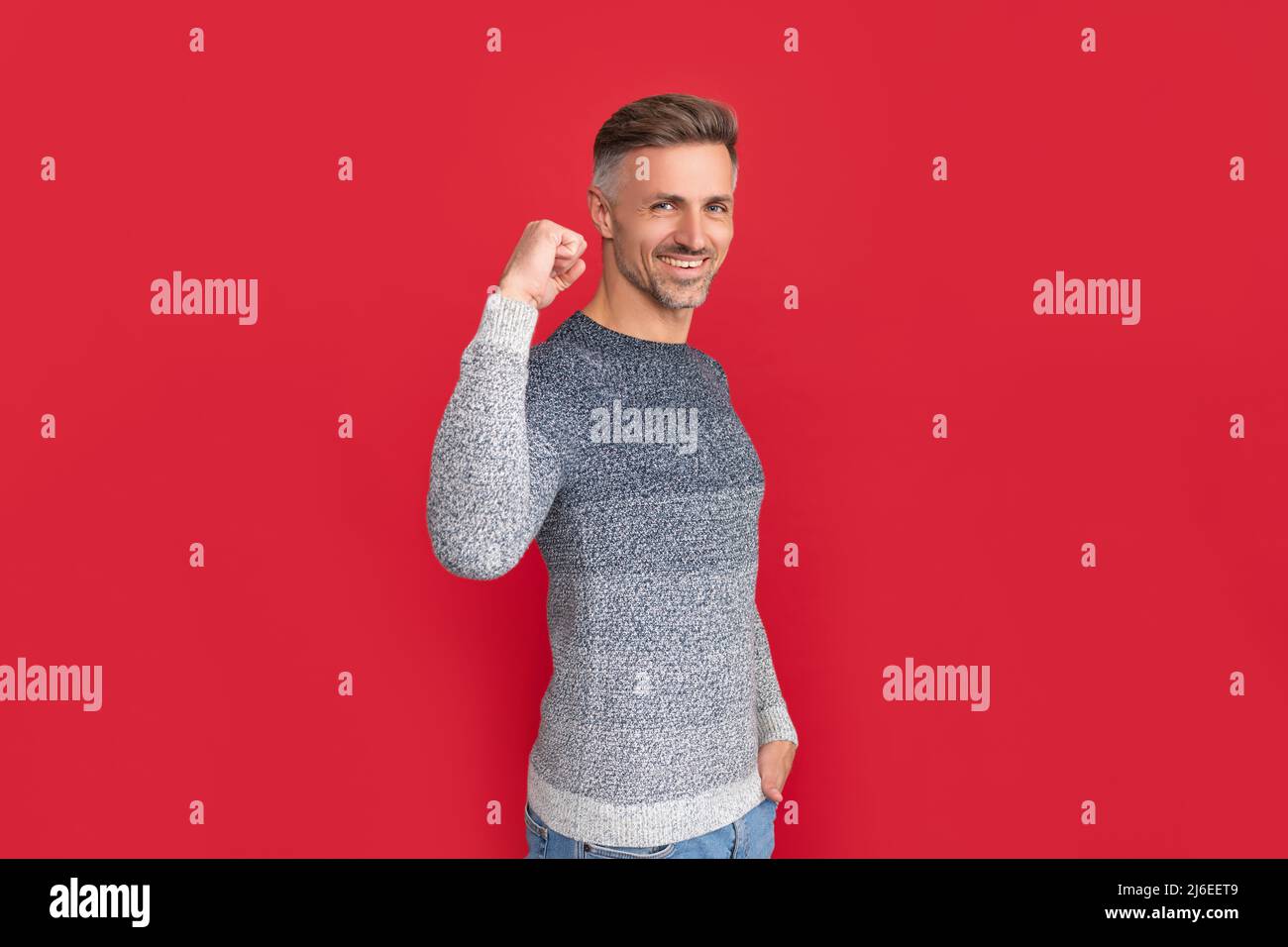 happy successful man in sweater on red background, success Stock Photo ...