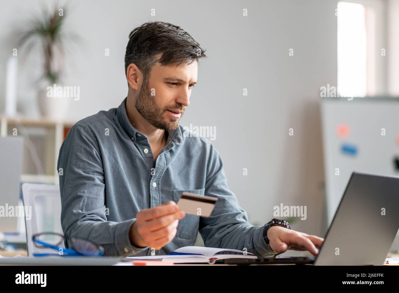 E-commerce concept. Mature businessman using credit card and laptop ...
