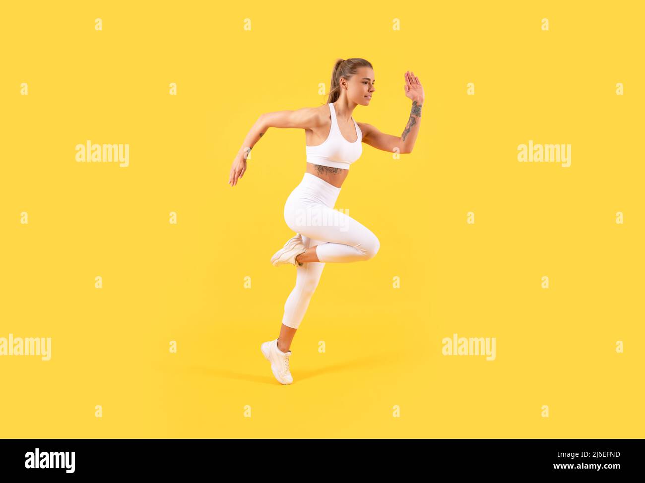 Jumping woman in yellow hi-res stock photography and images - Alamy