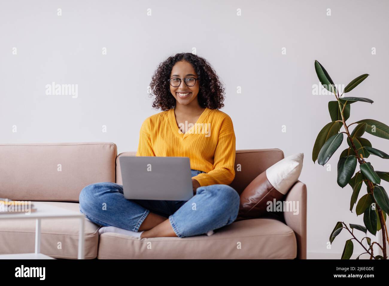 Happy millennial black woman in glasses using laptop computer, sitting ...