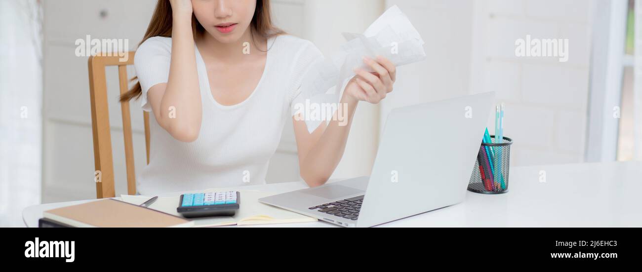 Young asian woman calculating expenses household about finance and ...