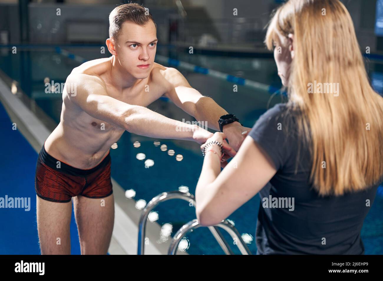 Athletic woman pull slim guy hands toward herself before training in ...