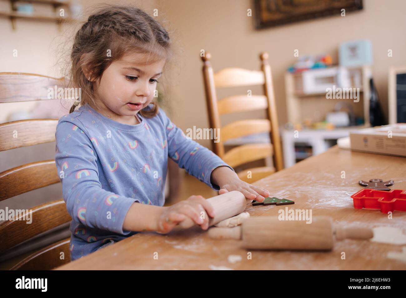 Little girl using rolling pin for making pizza at home. Close-up of ...