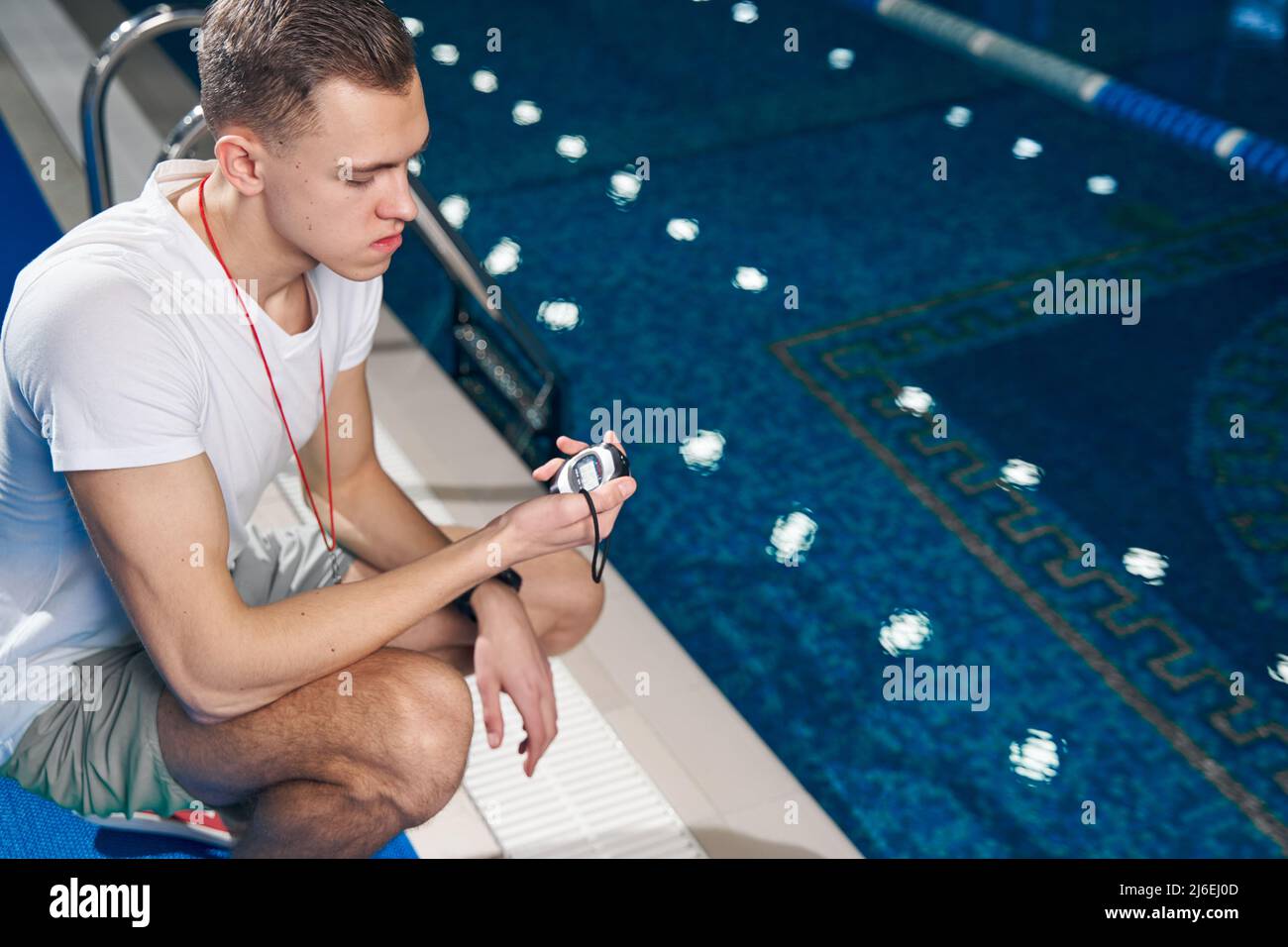 Male swimming coach crouching hi-res stock photography and images - Alamy