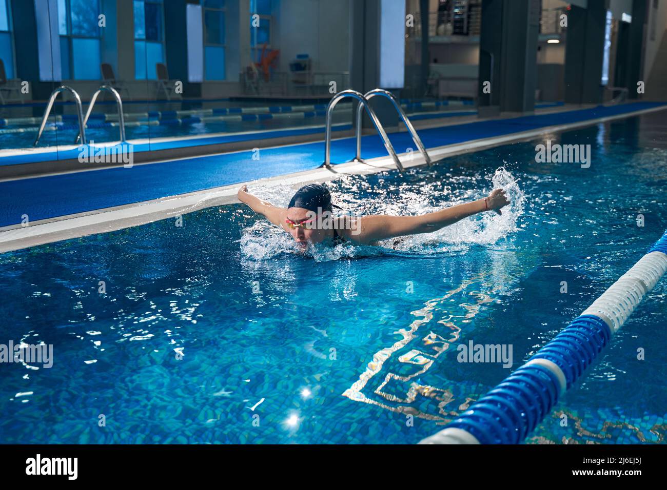 Young female swimming the butterfly in the pool Stock Photo - Alamy