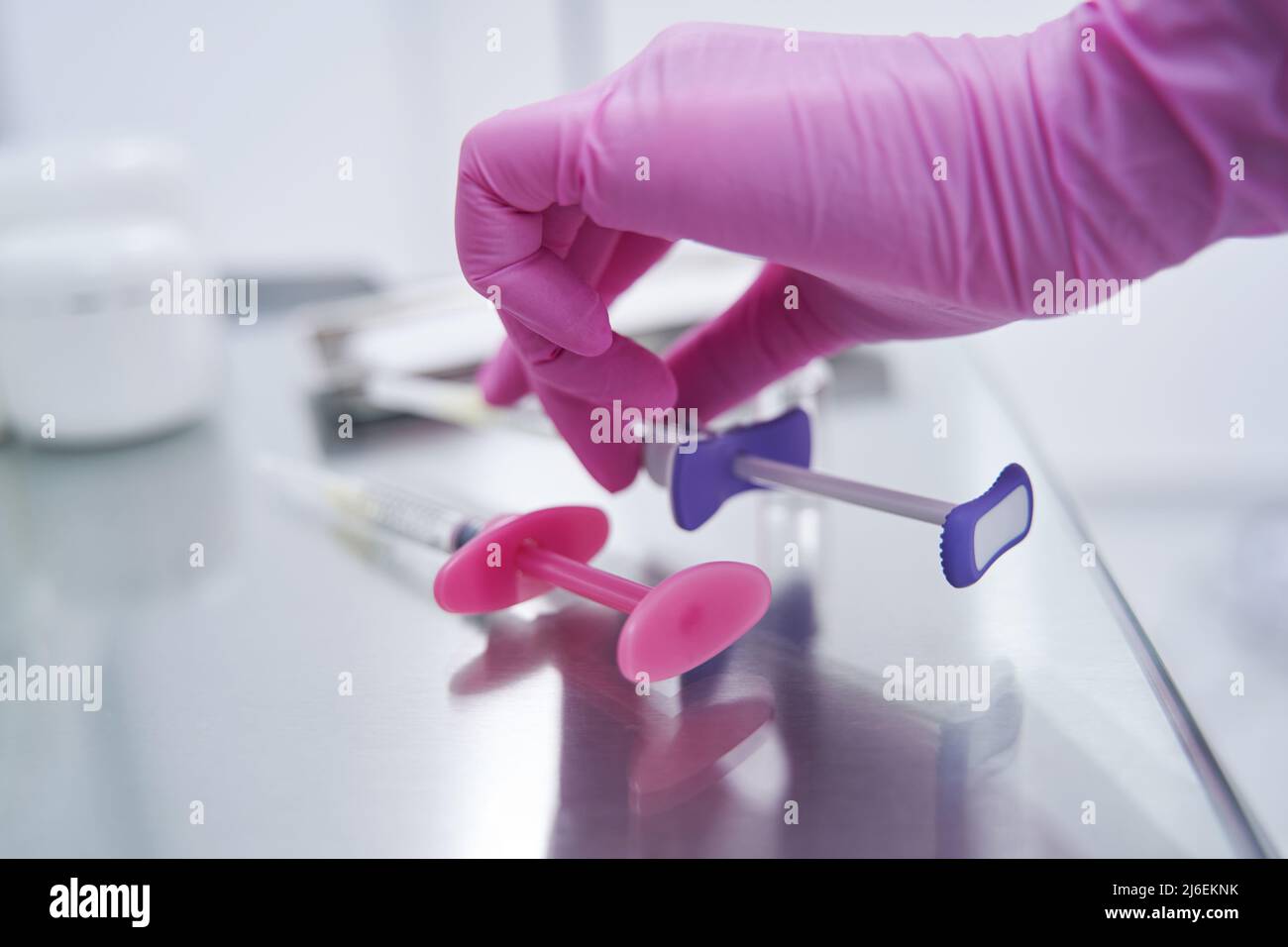 Competent medical worker taking syringe from support Stock Photo - Alamy