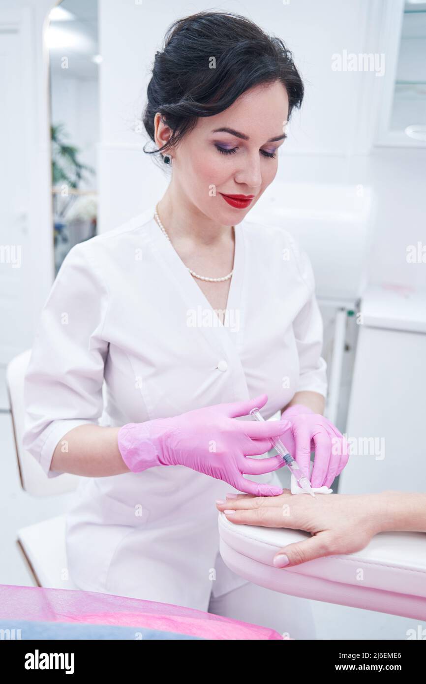 Positive delighted cosmetologist doing skin lifting procedure Stock ...