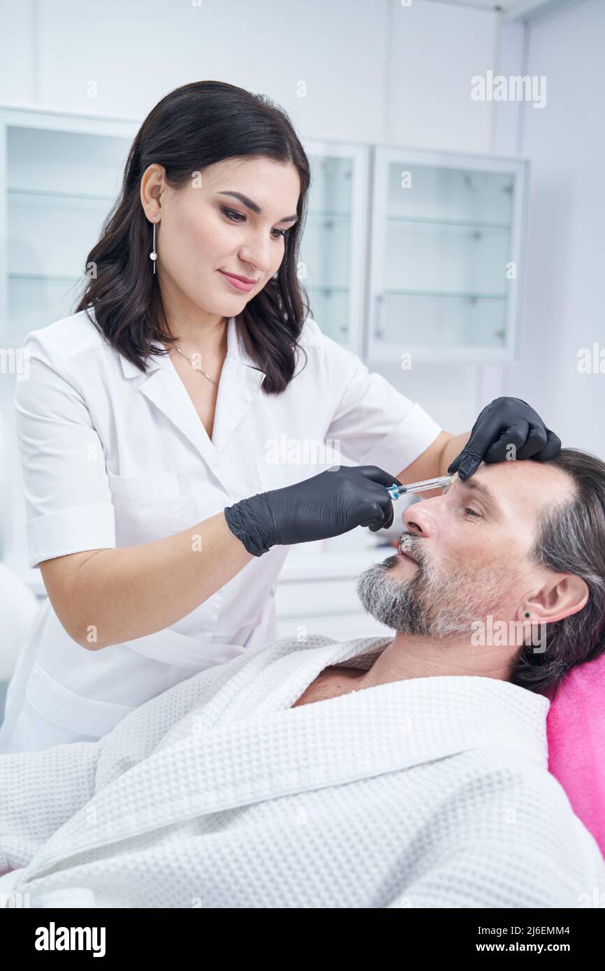 Positive delighted cosmetologist working in aesthetic medicine Stock ...