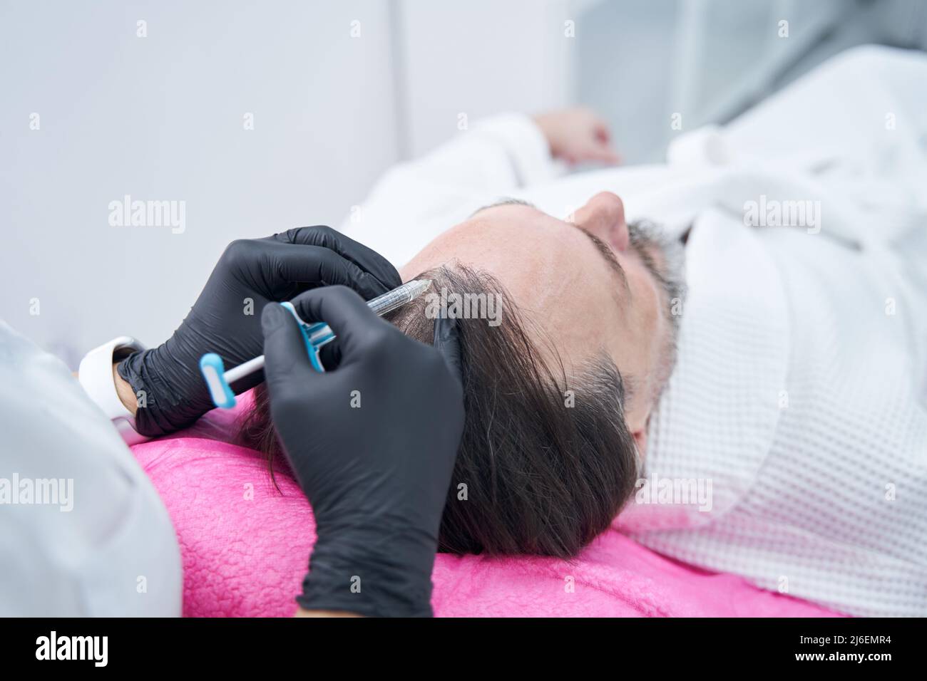 Adult male person receiving injection in his head Stock Photo - Alamy