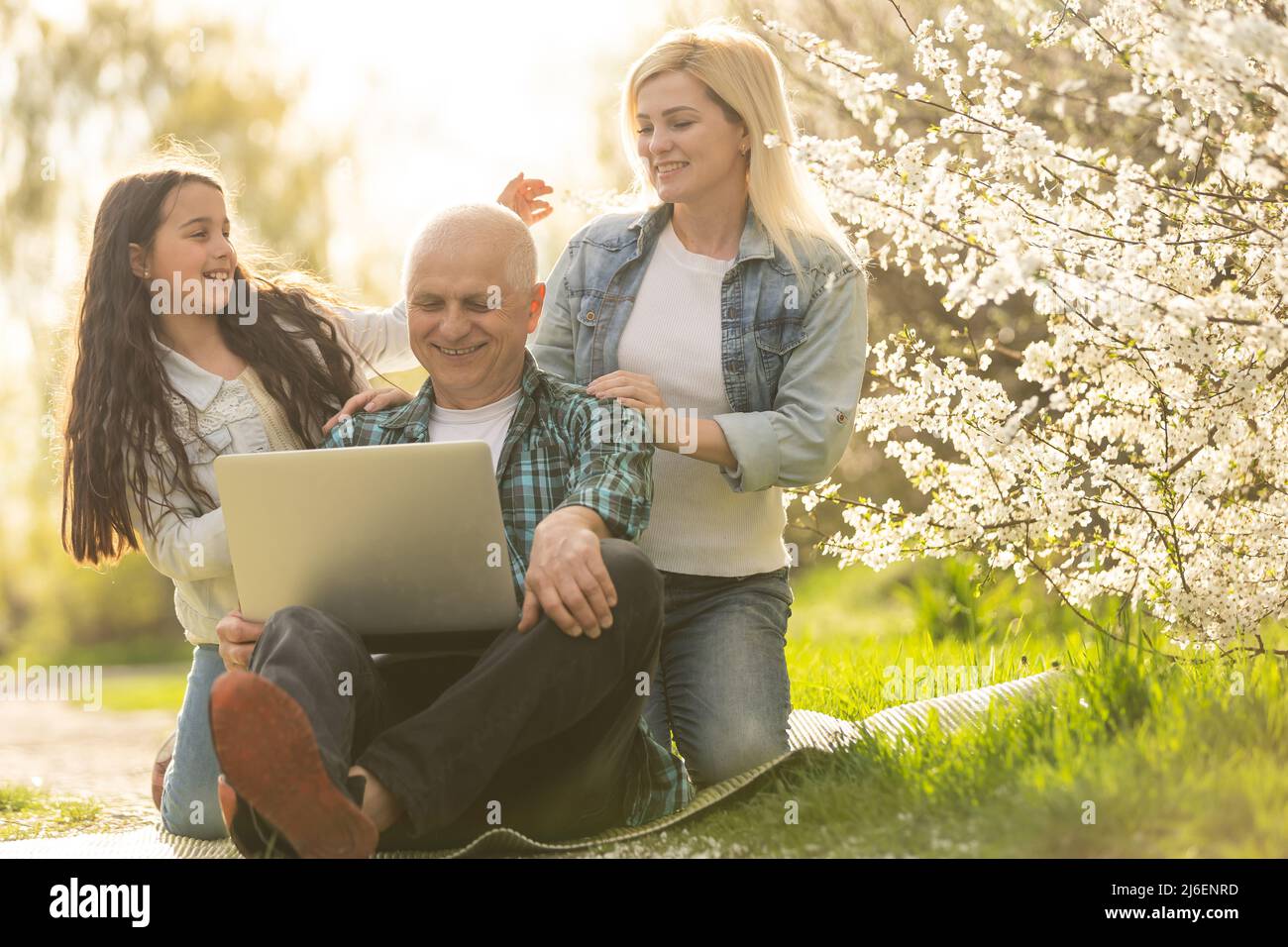 Elderly man explains how to use a laptop to his granddaughter Stock ...