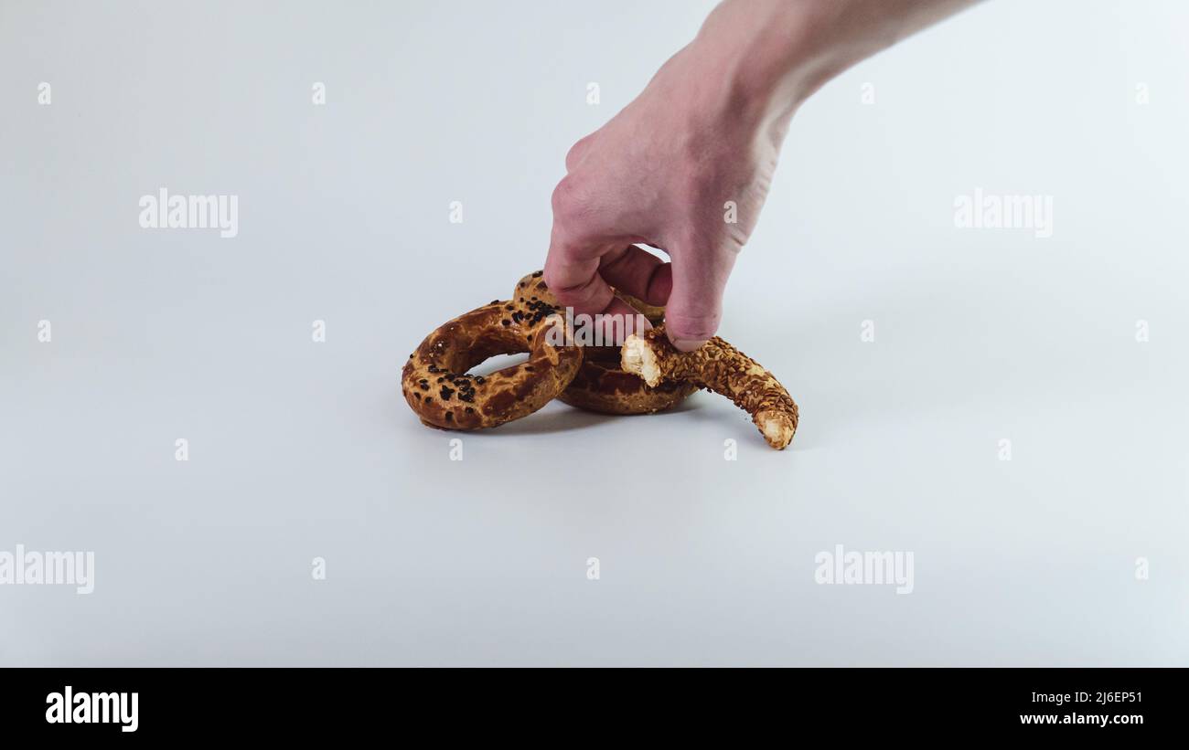 A woman hold traditional turkish sesame rings Kandil Simidi on a white ...
