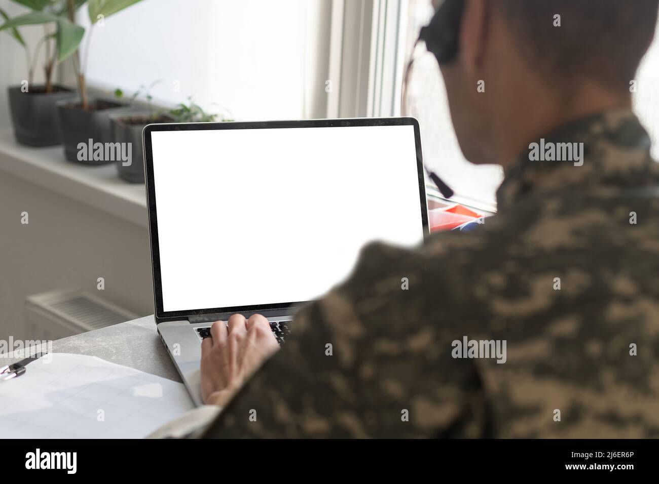 Army. Young soldier working with a laptop computer with blank screen on ...