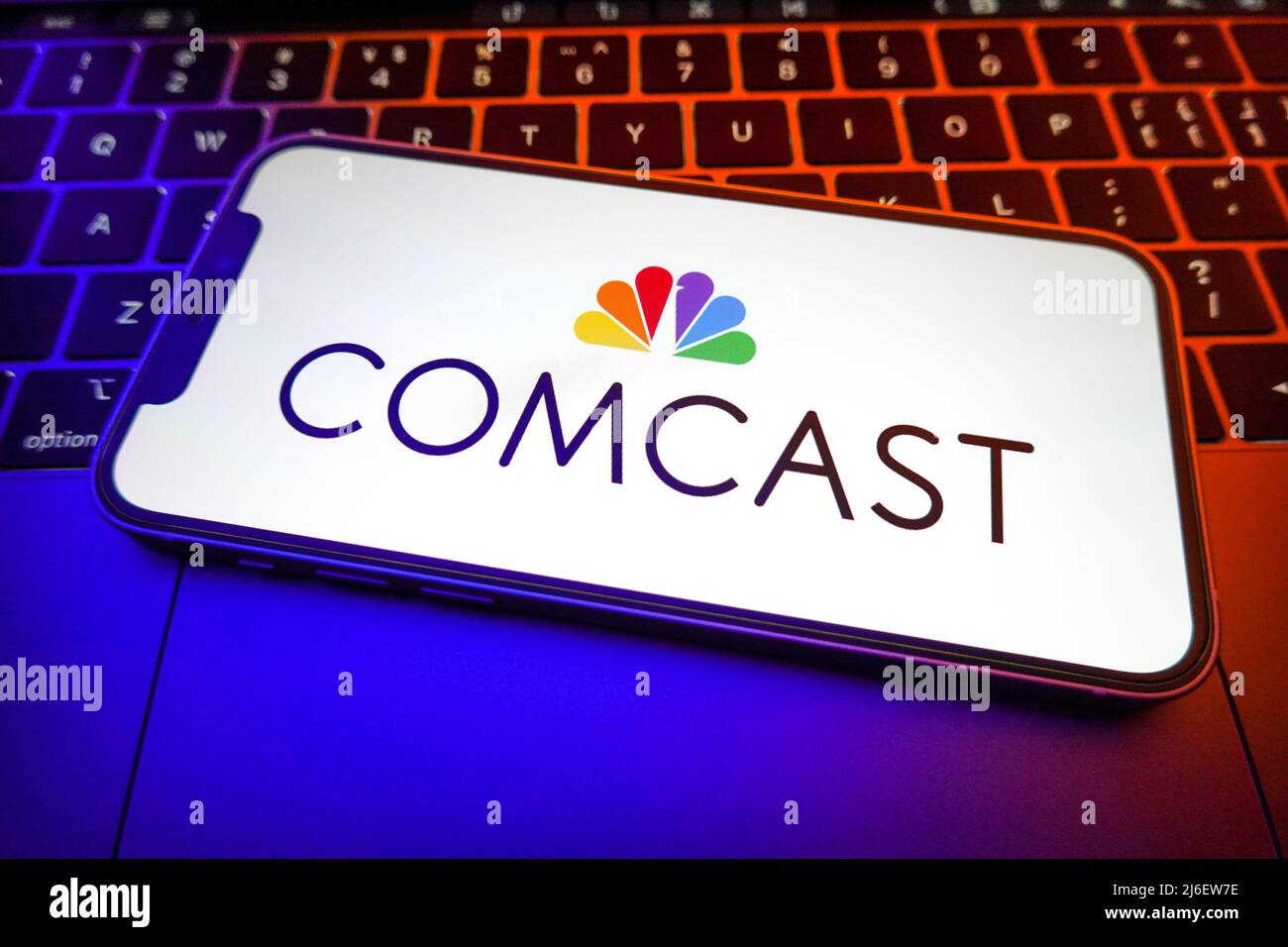 In this photo illustration, a Comcast logo is displayed on the screen ...