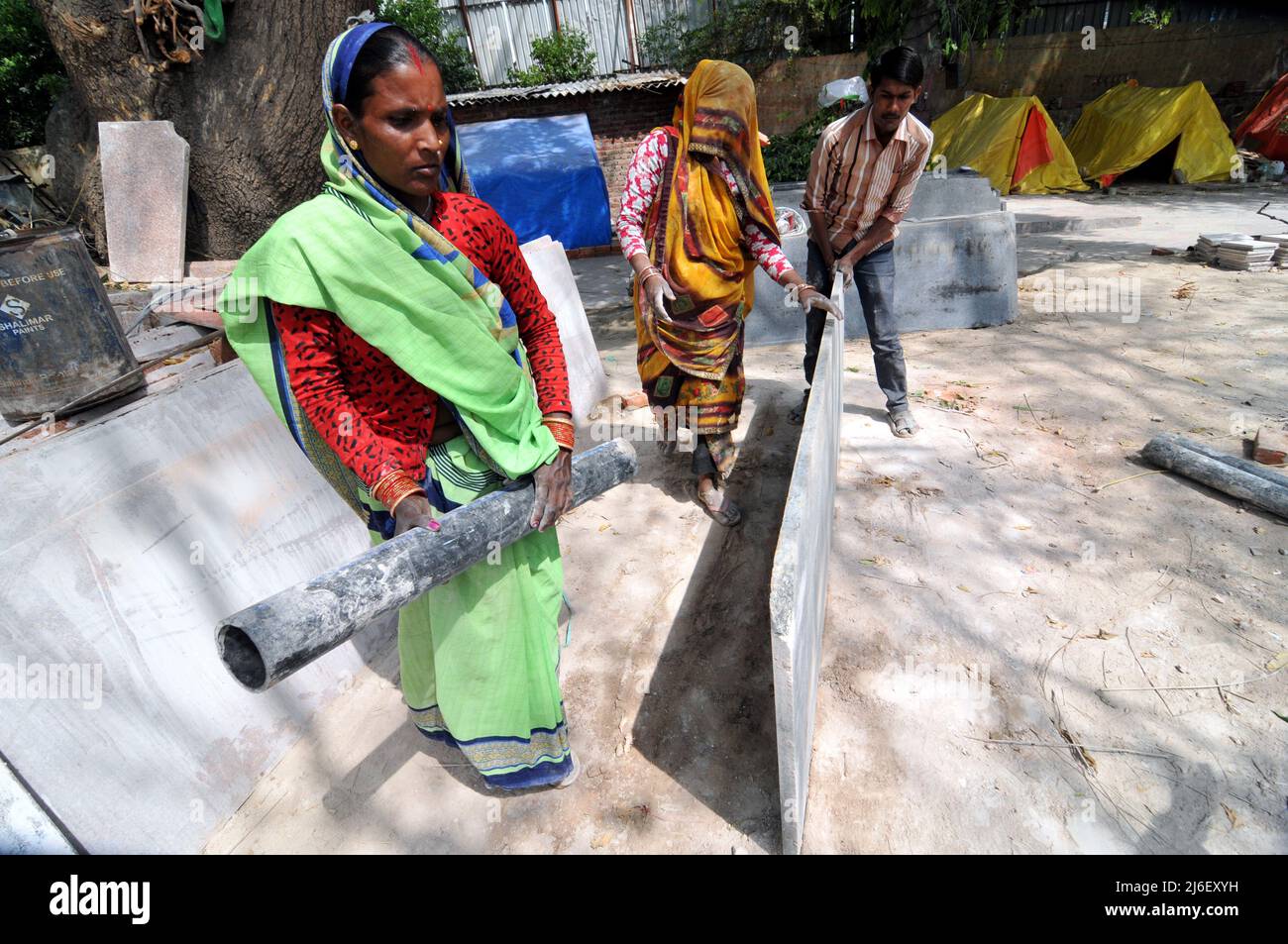 Men and women are seen working on the streets of New Delhi, India, on ...