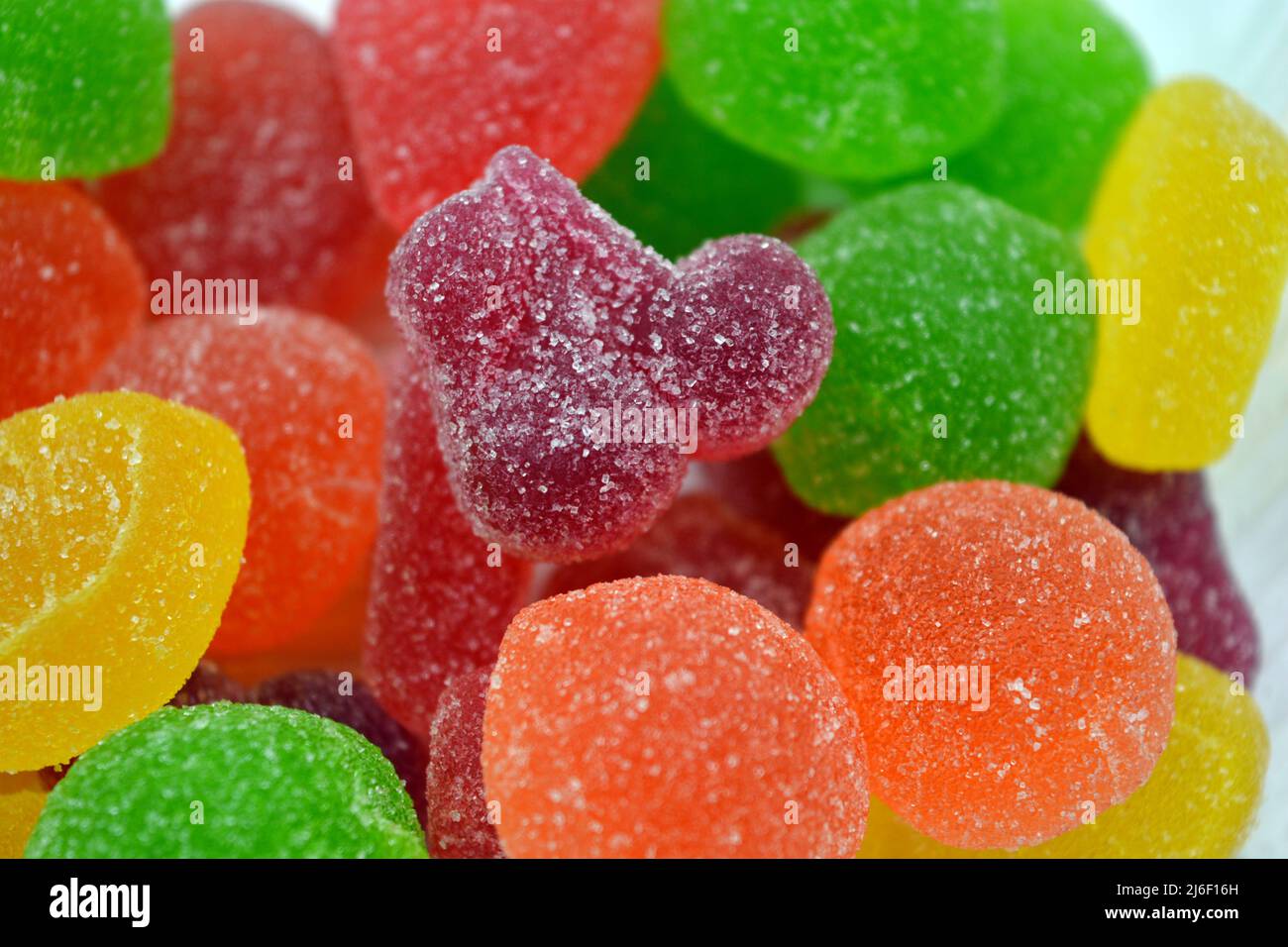 Multi-colored sweets in the form of fruits of different colors: red ...