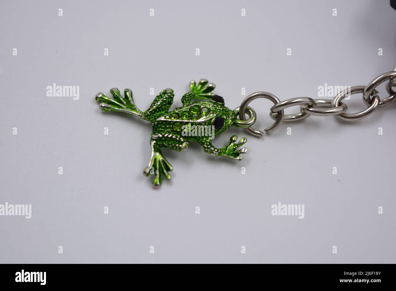 A beautiful, bright keychain decorated with small green frogs, toads ...