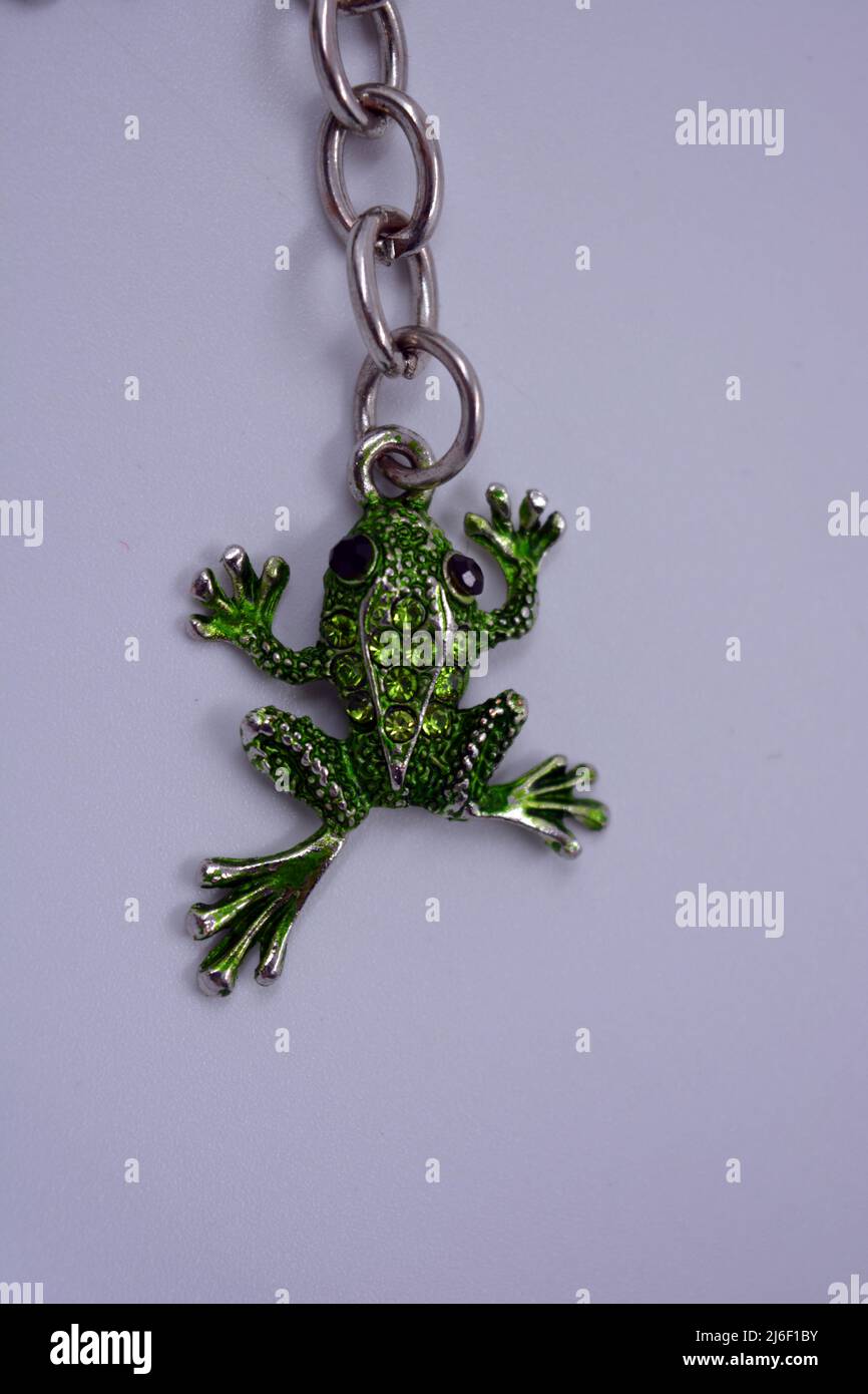 A beautiful, bright keychain decorated with small green frogs, toads ...
