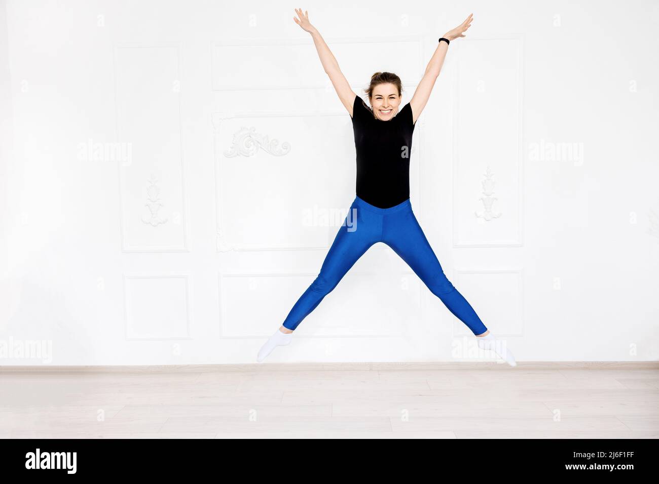 Going crazy. Funny positive young female jumping at a white background ...