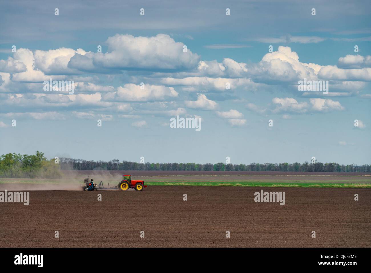 Red ukrainian tractor on the plowed field. Agricultural industry in ...