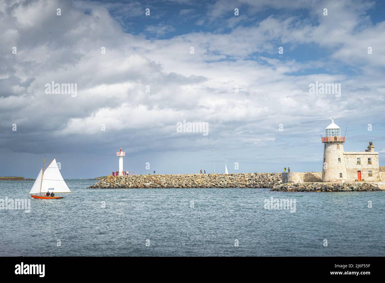 People on a small sailboat exiting Howth marina, passing Howth ...