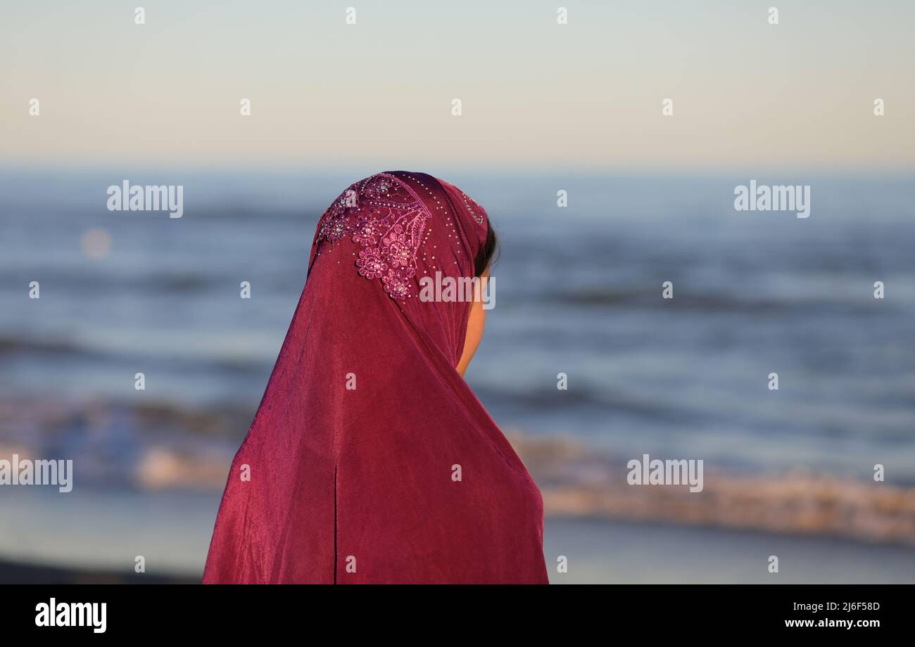 young woman with arabic veil on her head by the sea waiting Stock Photo ...