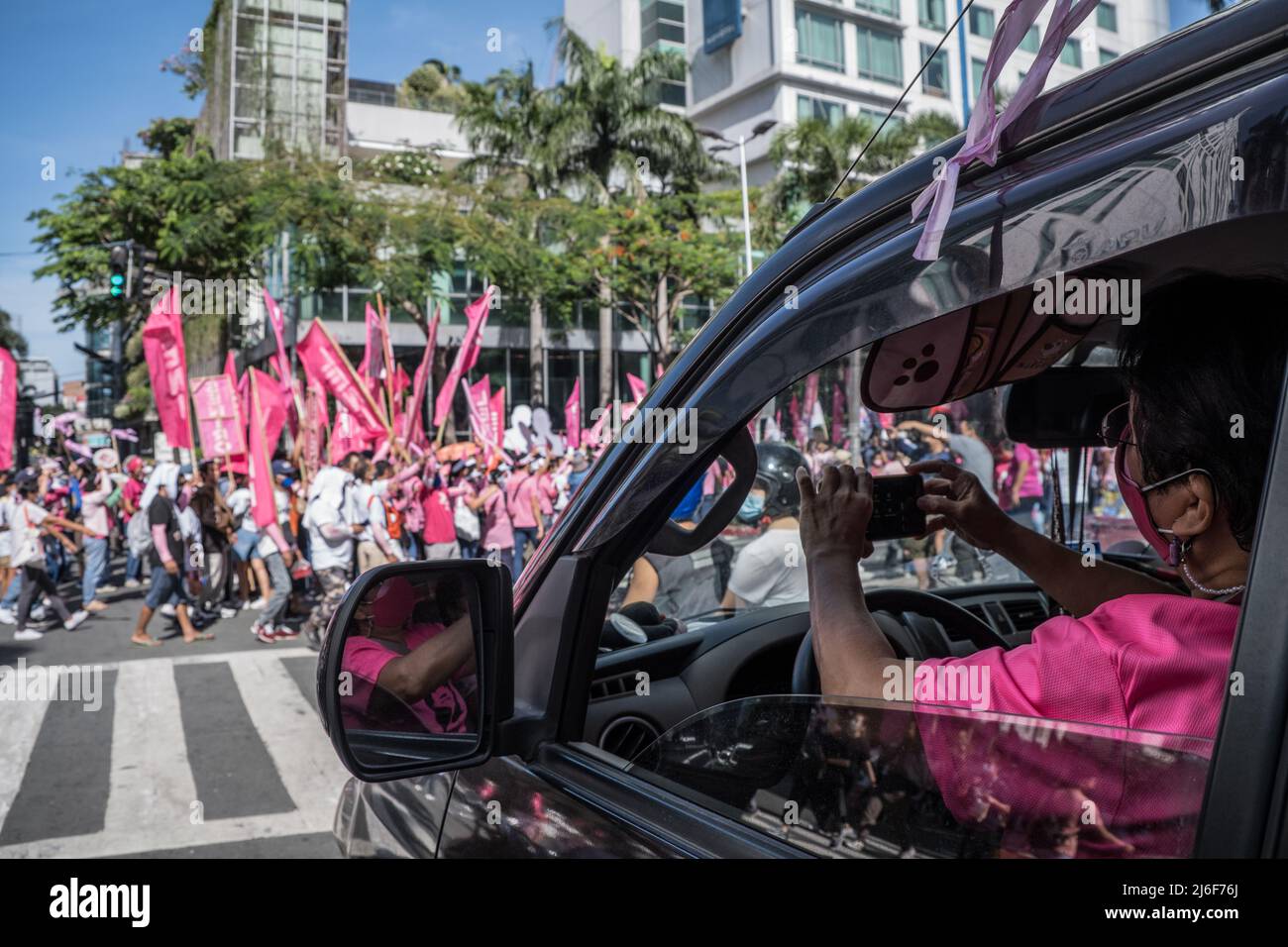 Stopped motorist take photos of Leni-Kiko supporters as they march to ...