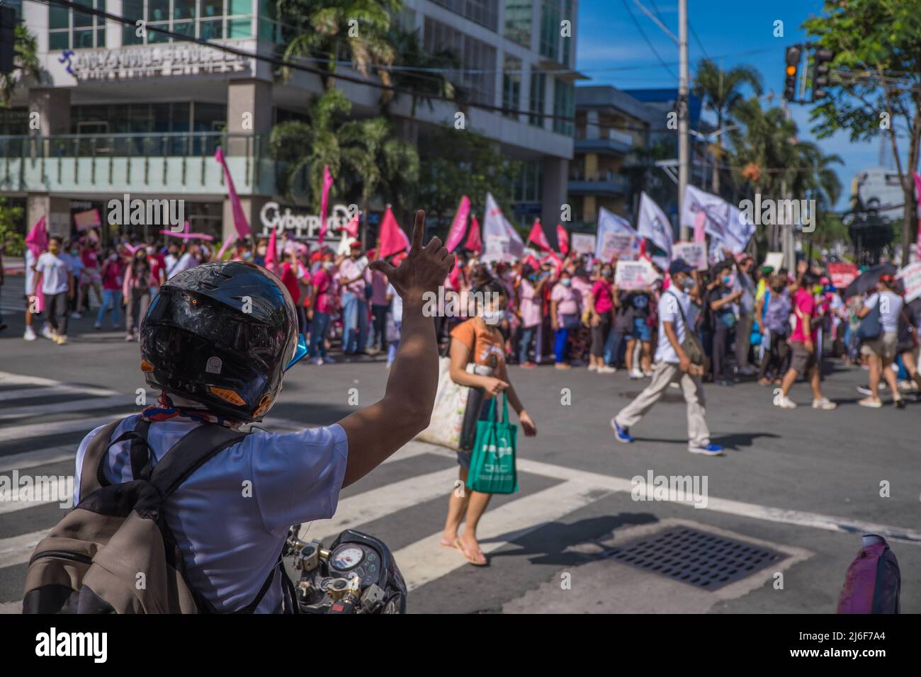 Stopped motorist flash the L sign to Leni-Kiko supporters as they march ...