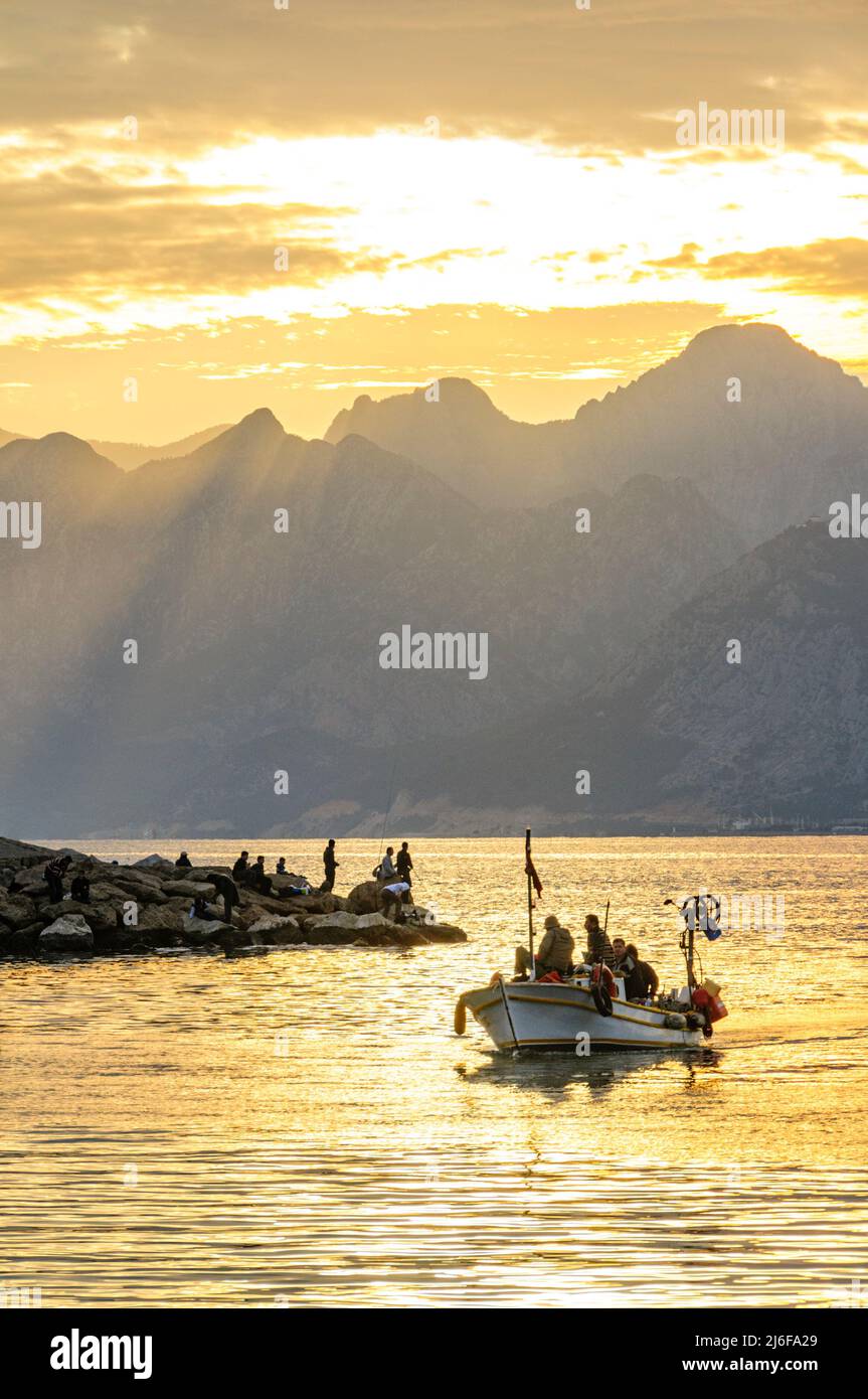 Boats bobbing in the harbor of Antalya in front of the evening scenery ...