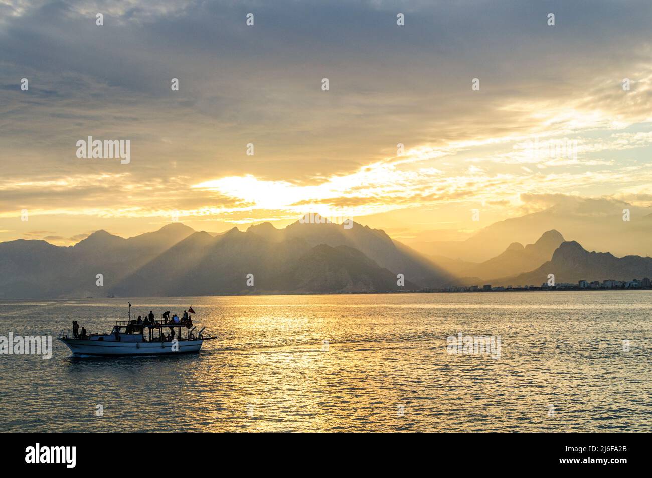 Boats bobbing in the harbor of Antalya in front of the evening scenery ...