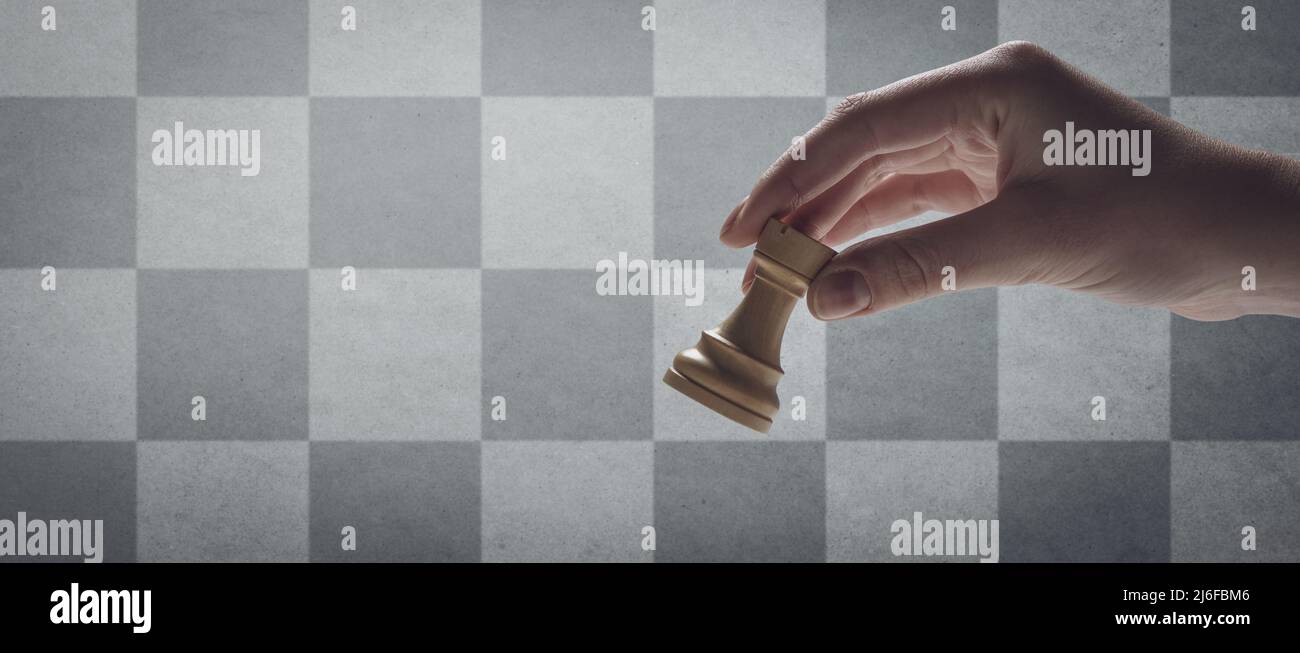 Chess player holding a rook, chessboard in the background, blank copy ...