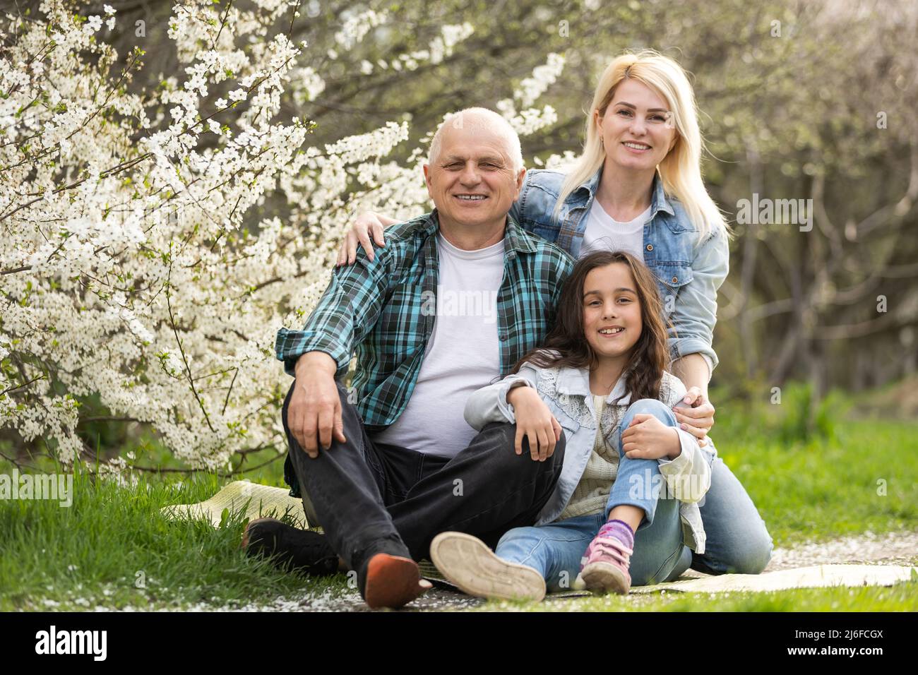 Three generation family sitting outside in spring nature Stock Photo ...