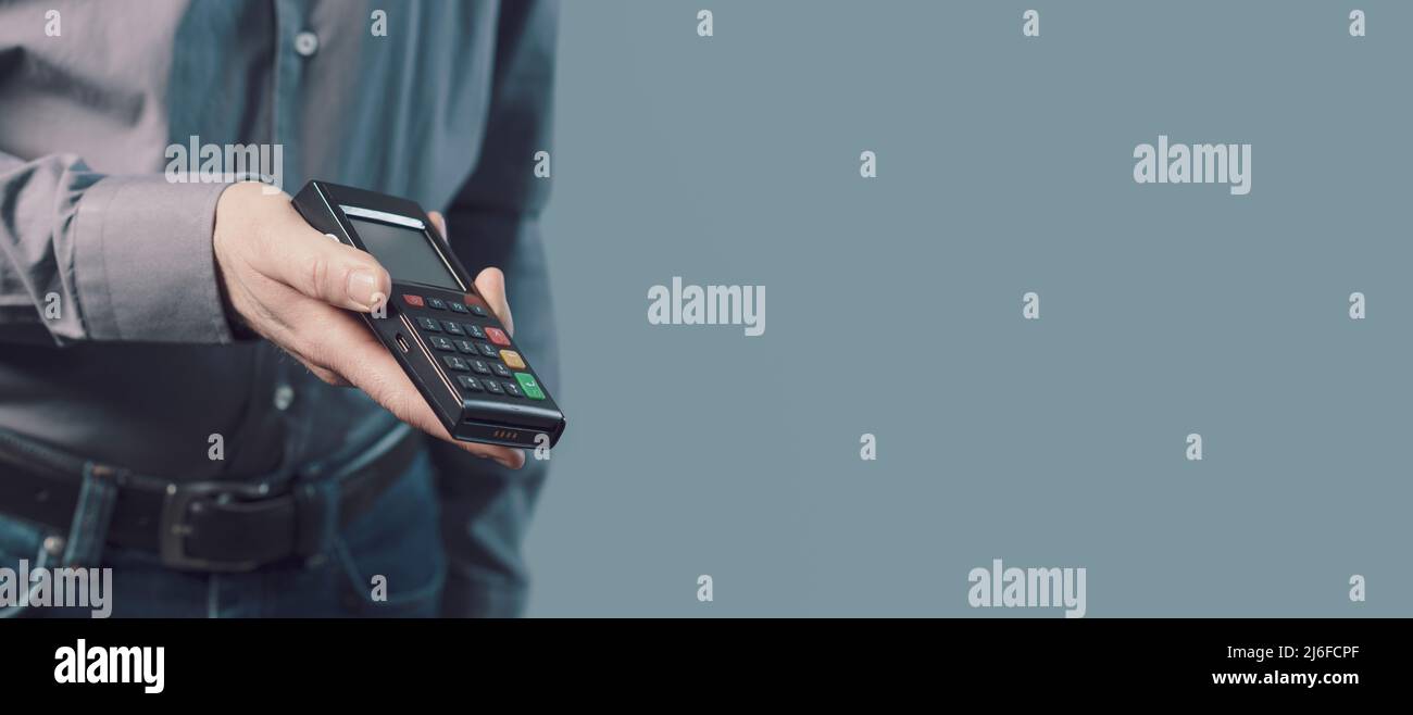 Man holding a POS terminal for digital payments, retail and e-payments ...