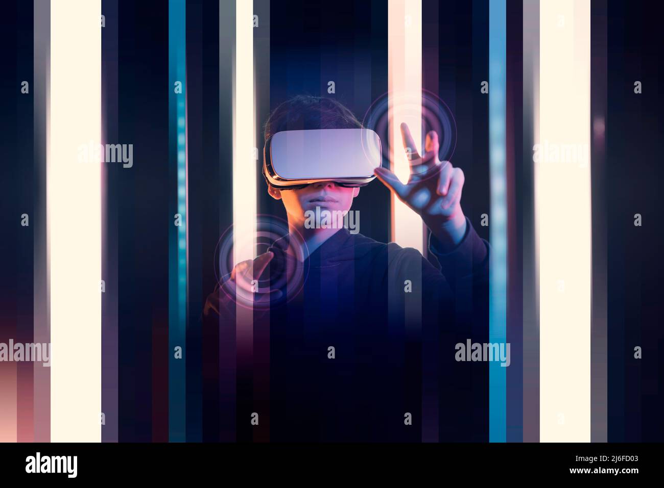 Teenager wearing a VR headset and using a touch screen interface in a ...