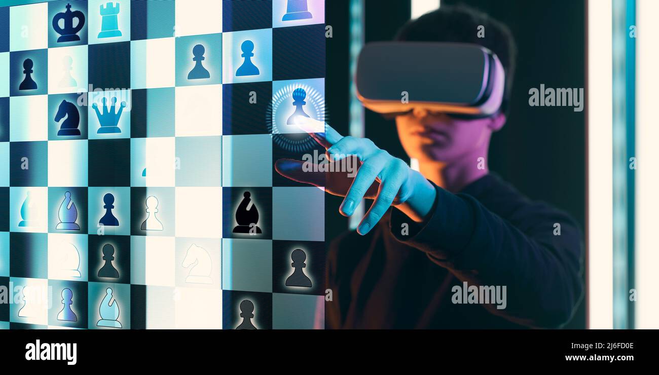 Teenager wearing a VR headset and playing chess in virtual reality, VR ...