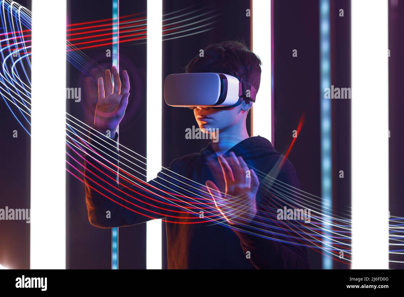 Teenager wearing a VR headset and experiencing virtual reality ...