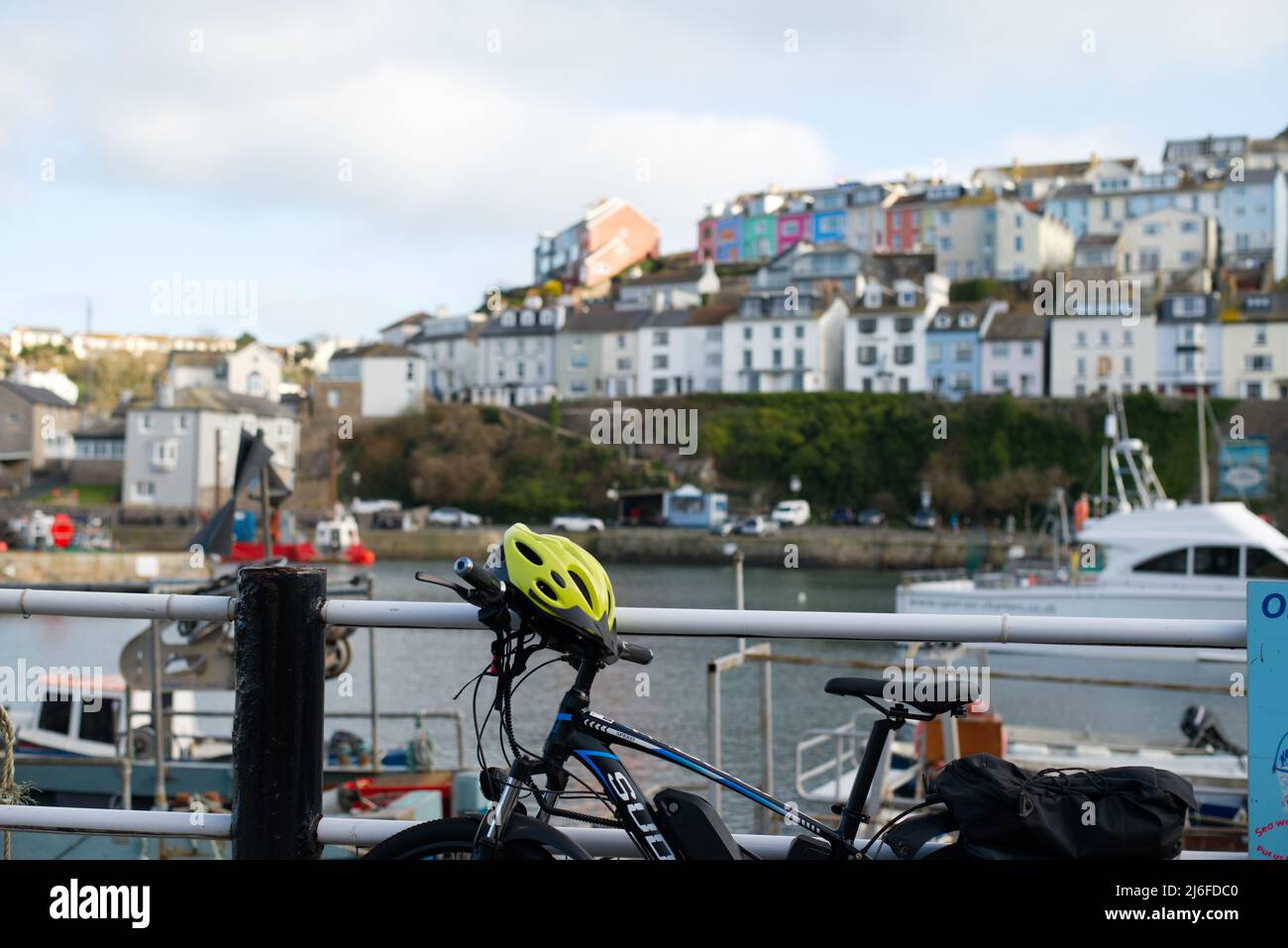 Boats, including sailboats, rest in Brixham Harbour. Terraced and ...