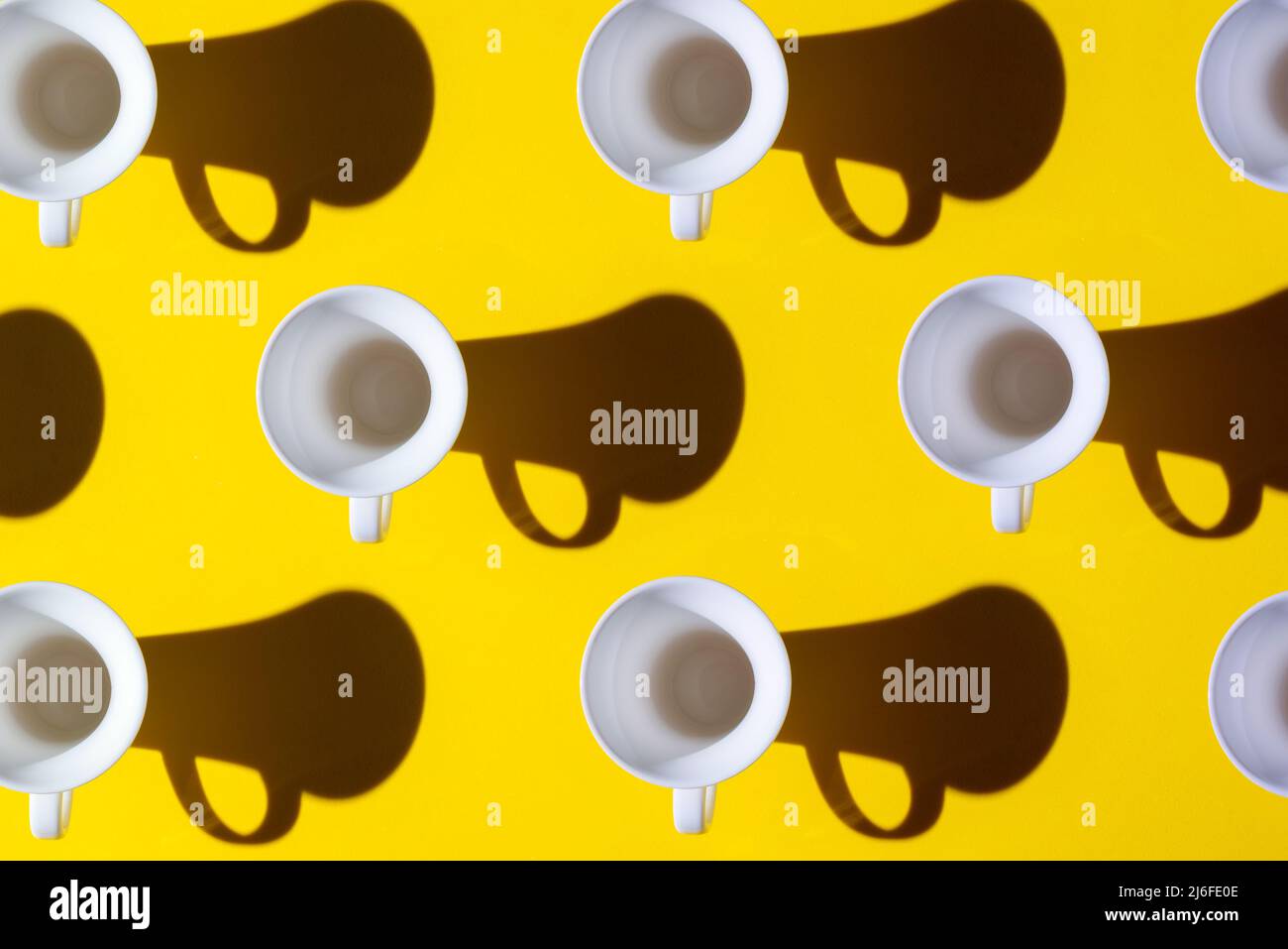 Pattern of coffee cups from a top view casting a hard shadow with the ...