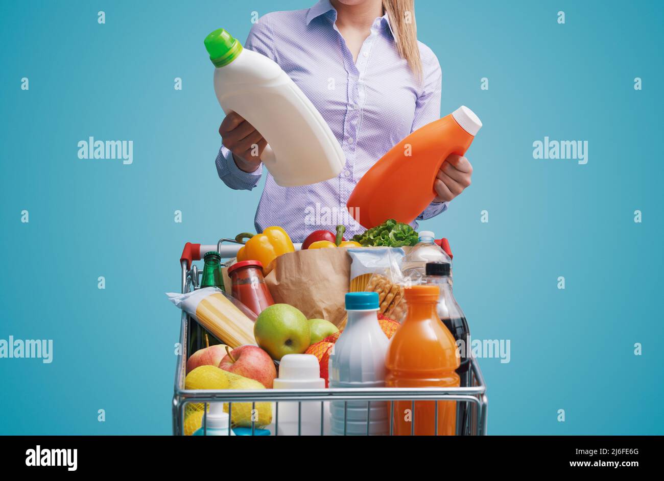 Woman doing grocery shopping at the supermarket and comparing products ...