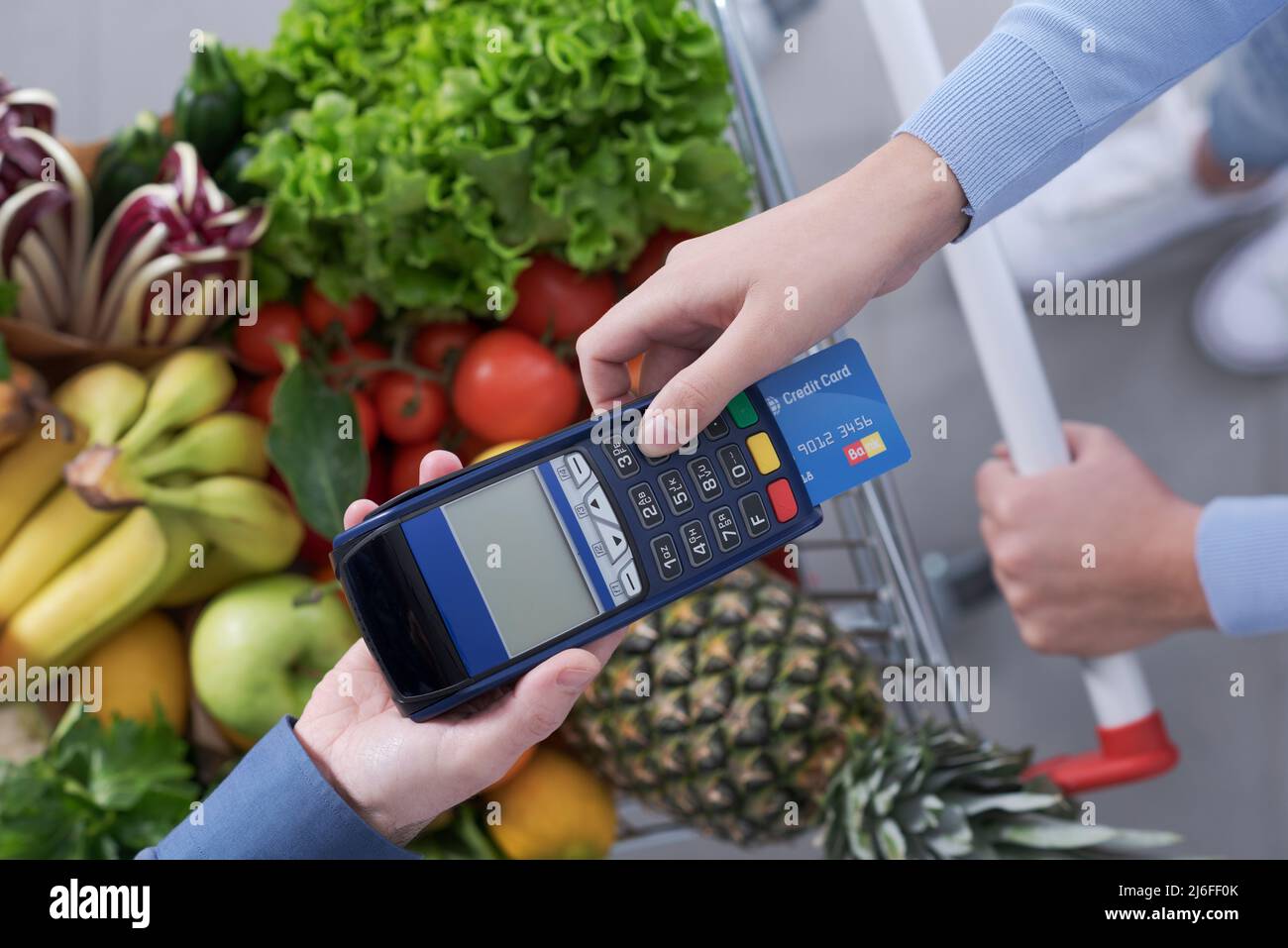 Woman paying for groceries using her credit card, the supermarket ...