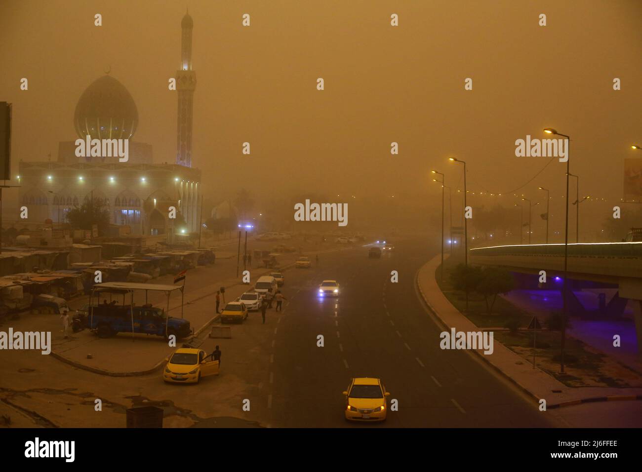 01 May 2022, Iraq, Baghdad: Vehicles move amid yellow dust due to dust ...