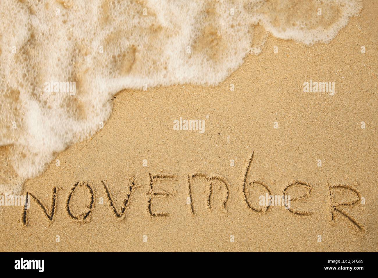 November - handwritten on the soft beach sand Stock Photo - Alamy