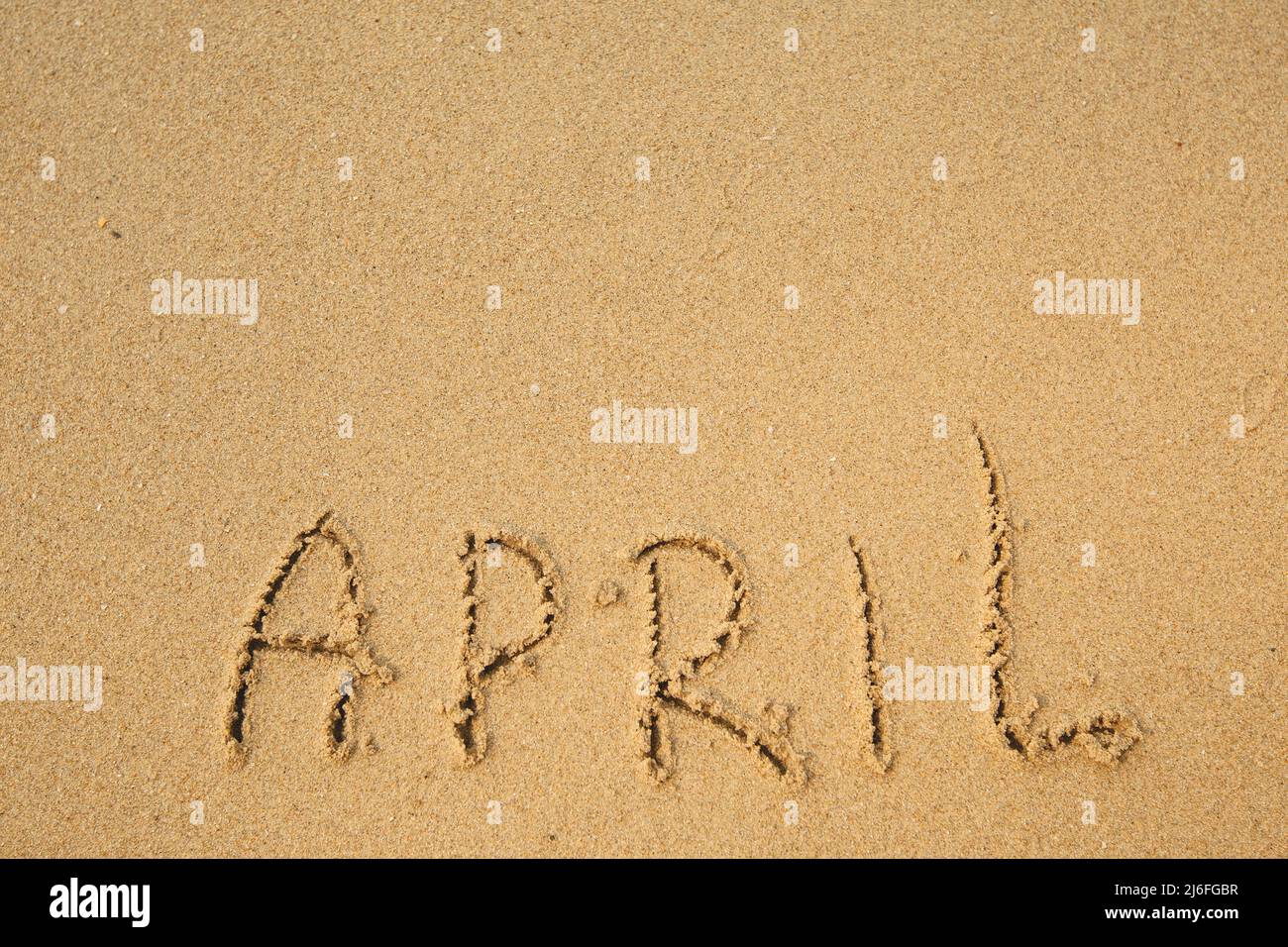 April - handwritten on the soft beach sand Stock Photo - Alamy