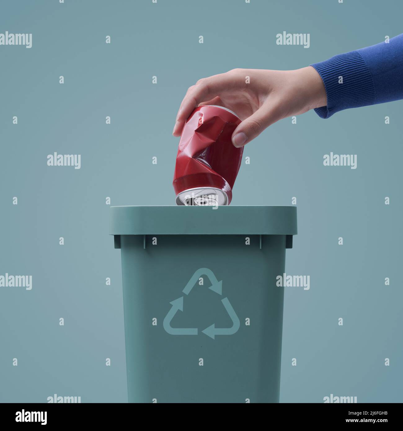 Woman putting a can in a garbage bin, separate waste collection and ...
