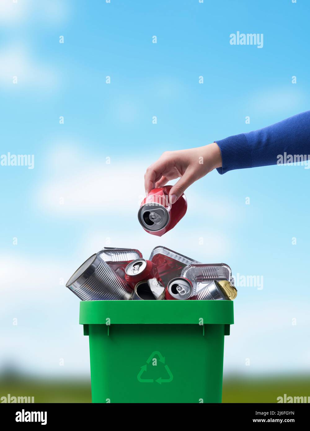 Woman throwing a metal can in the recycling bin, separate waste ...