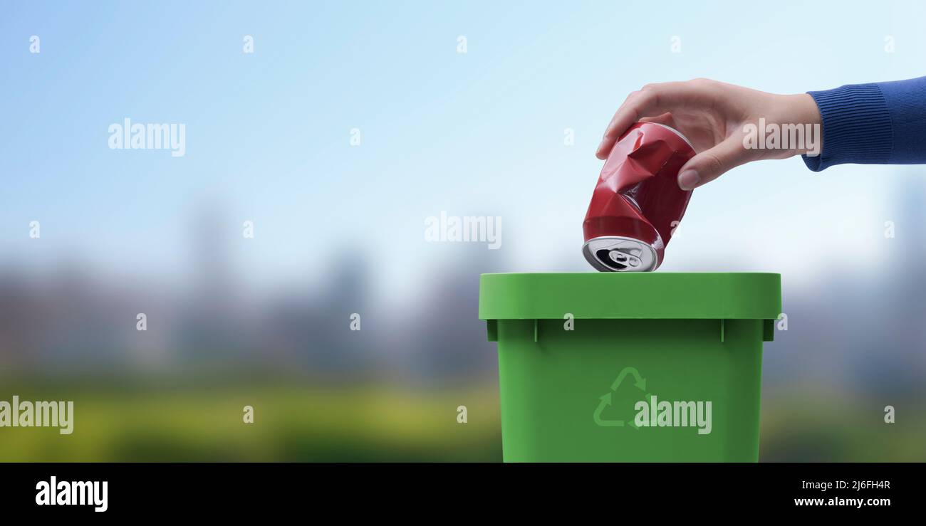 Woman putting a can in the trash bin, recycling concept, natural ...