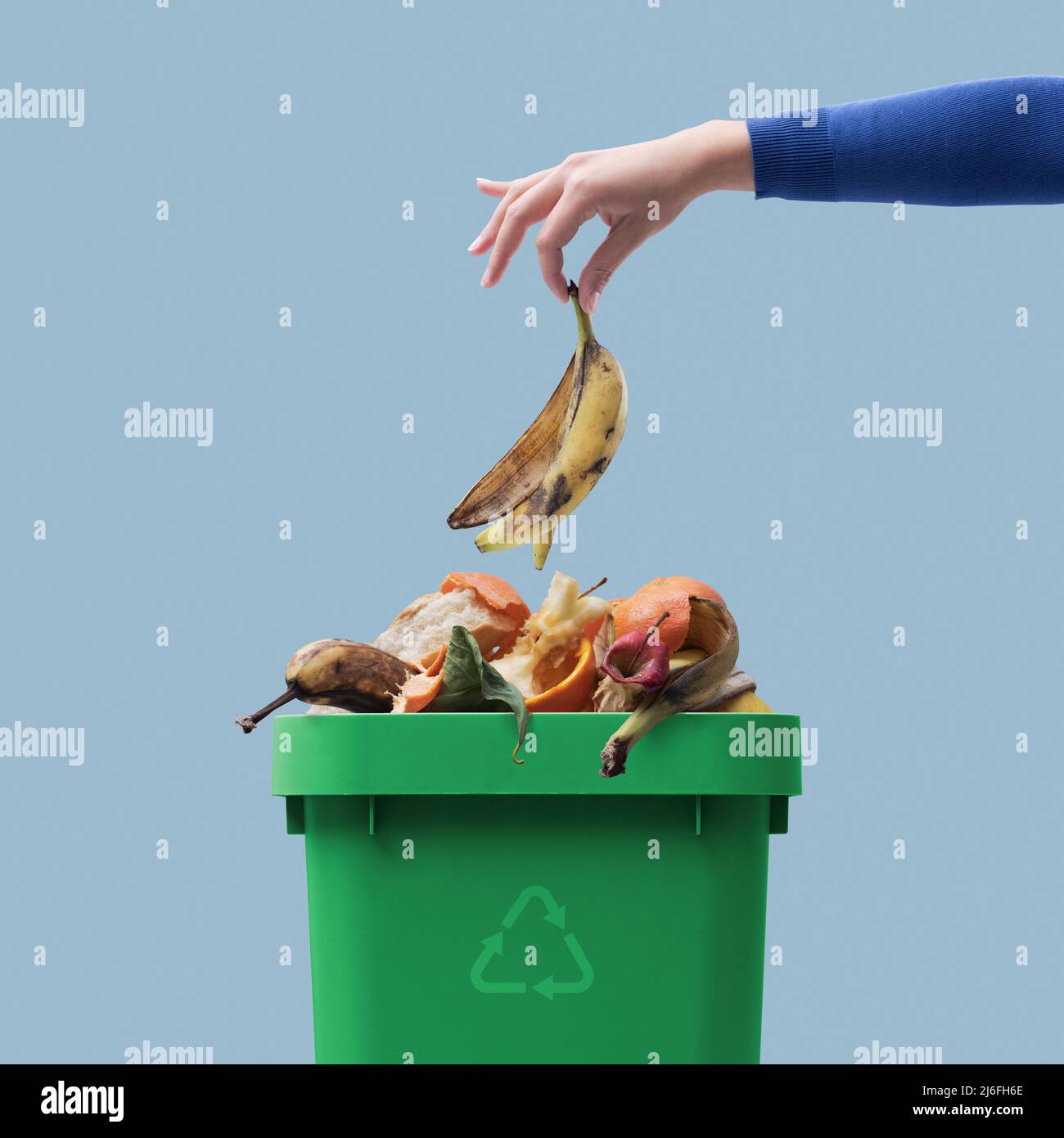 Woman putting organic biodegradable waste in a recycling bin, separate ...