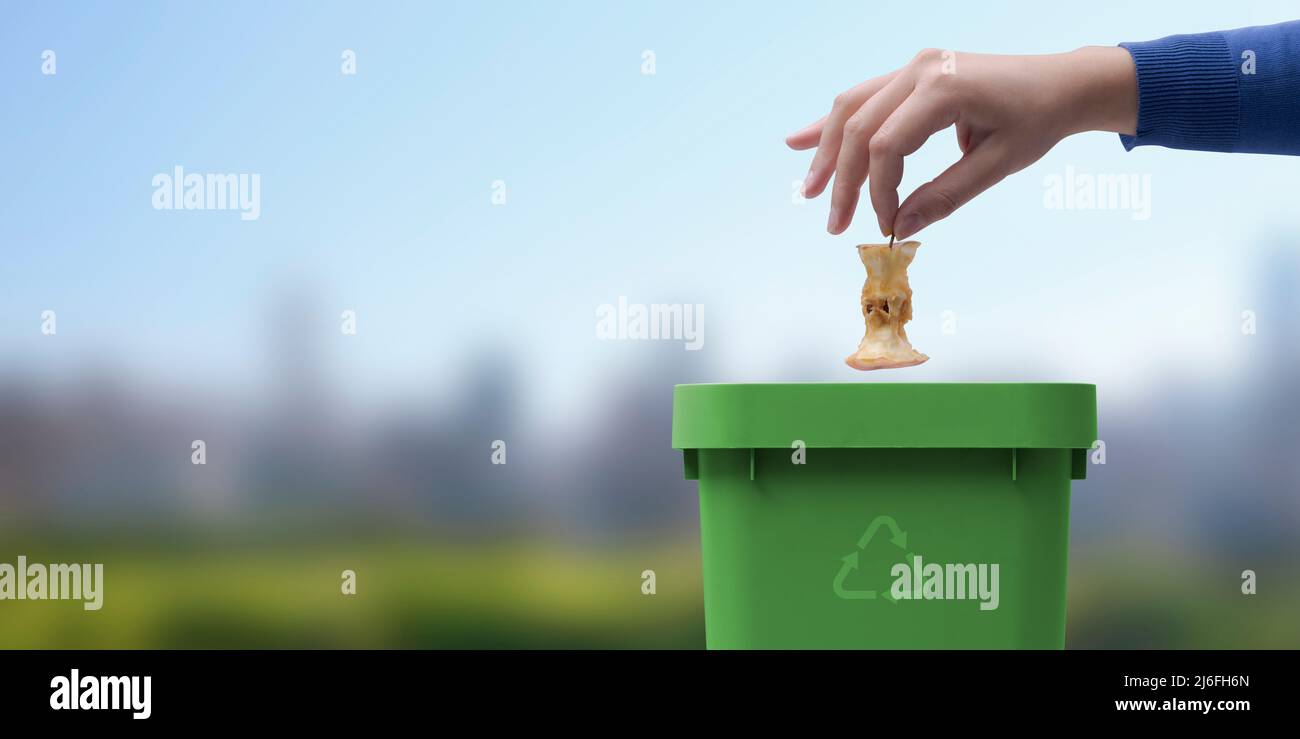 Woman putting biodegradable organic waste in a bin, recycling and waste ...