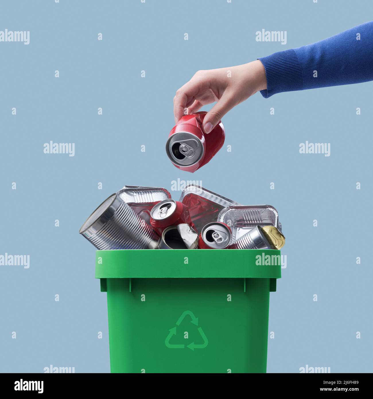 Woman throwing a metal can in the recycling bin, separate waste ...
