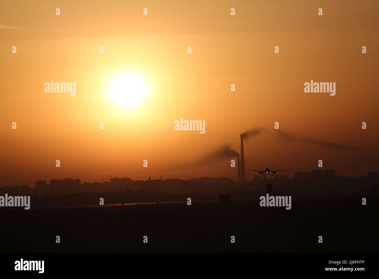 Transportation concept. Airplane landing at the airport, rising sun at ...